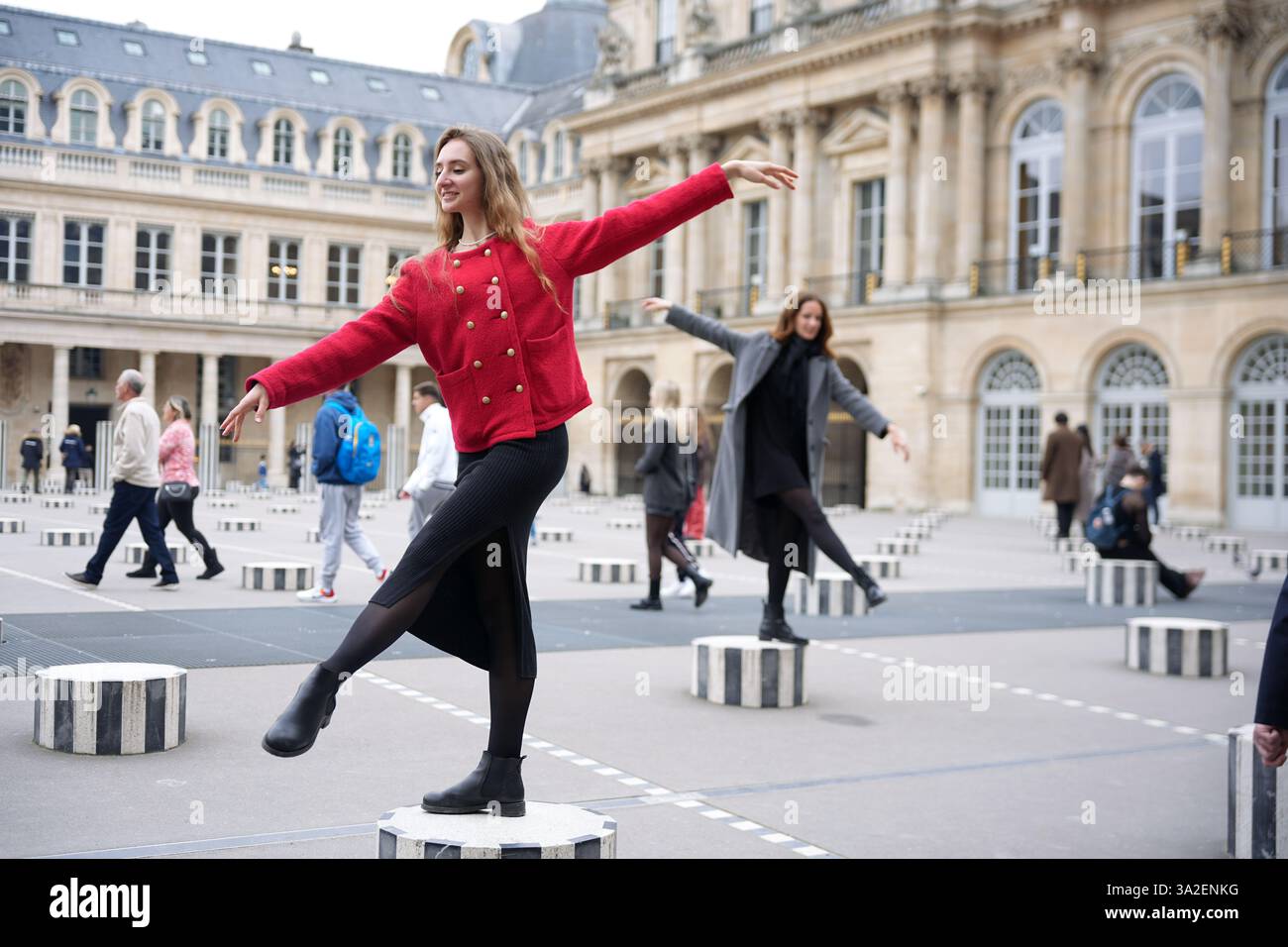Two stylish women pose gracefully on black-and-white columns at Palais ...