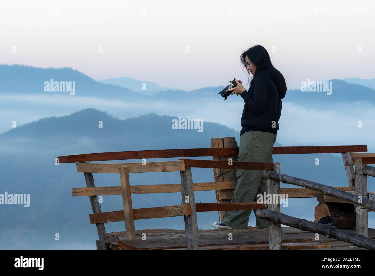 The female tourist is taking photos of the sea of mist in the morning ...