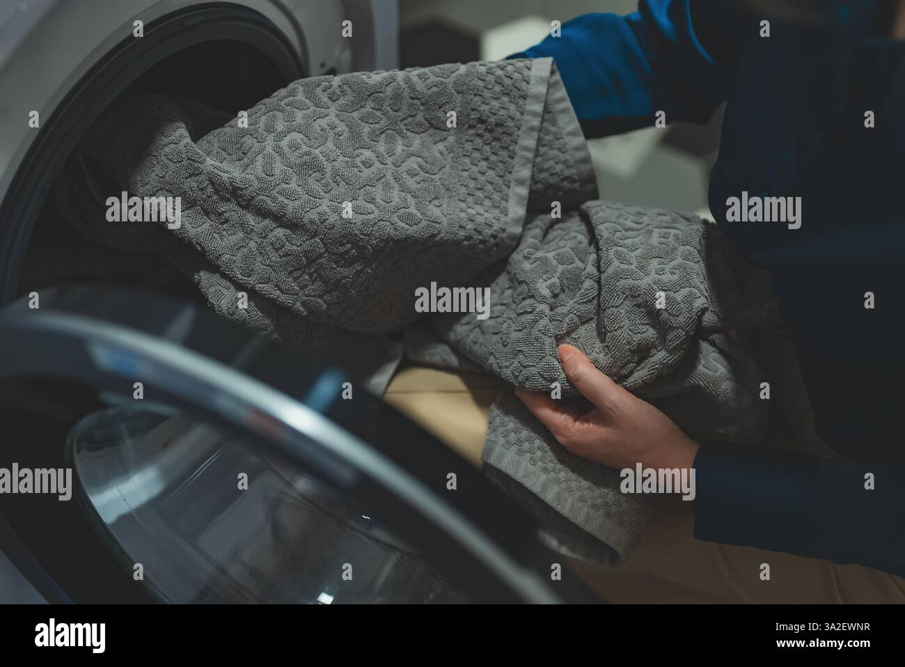 Woman loading laundry into a washing machine Stock Photo - Alamy