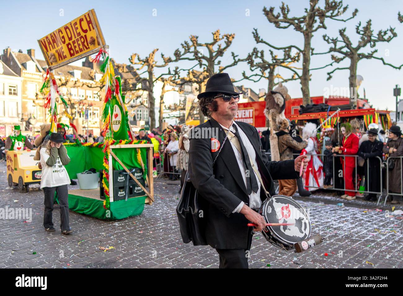 People in masks and costumes parade through the streets of Maastricht ...