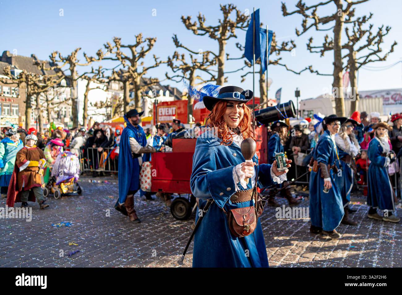People in masks and costumes parade through the streets of Maastricht ...