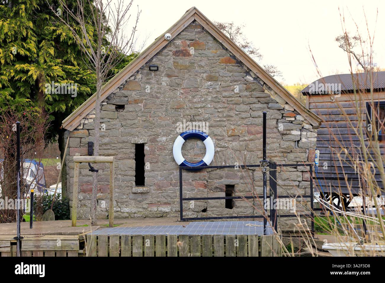 Small square stone building with life belt on the banks of the river ...