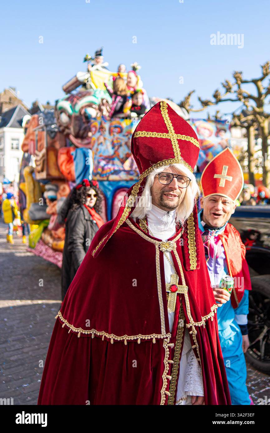 People in masks and costumes parade through the streets of Maastricht ...