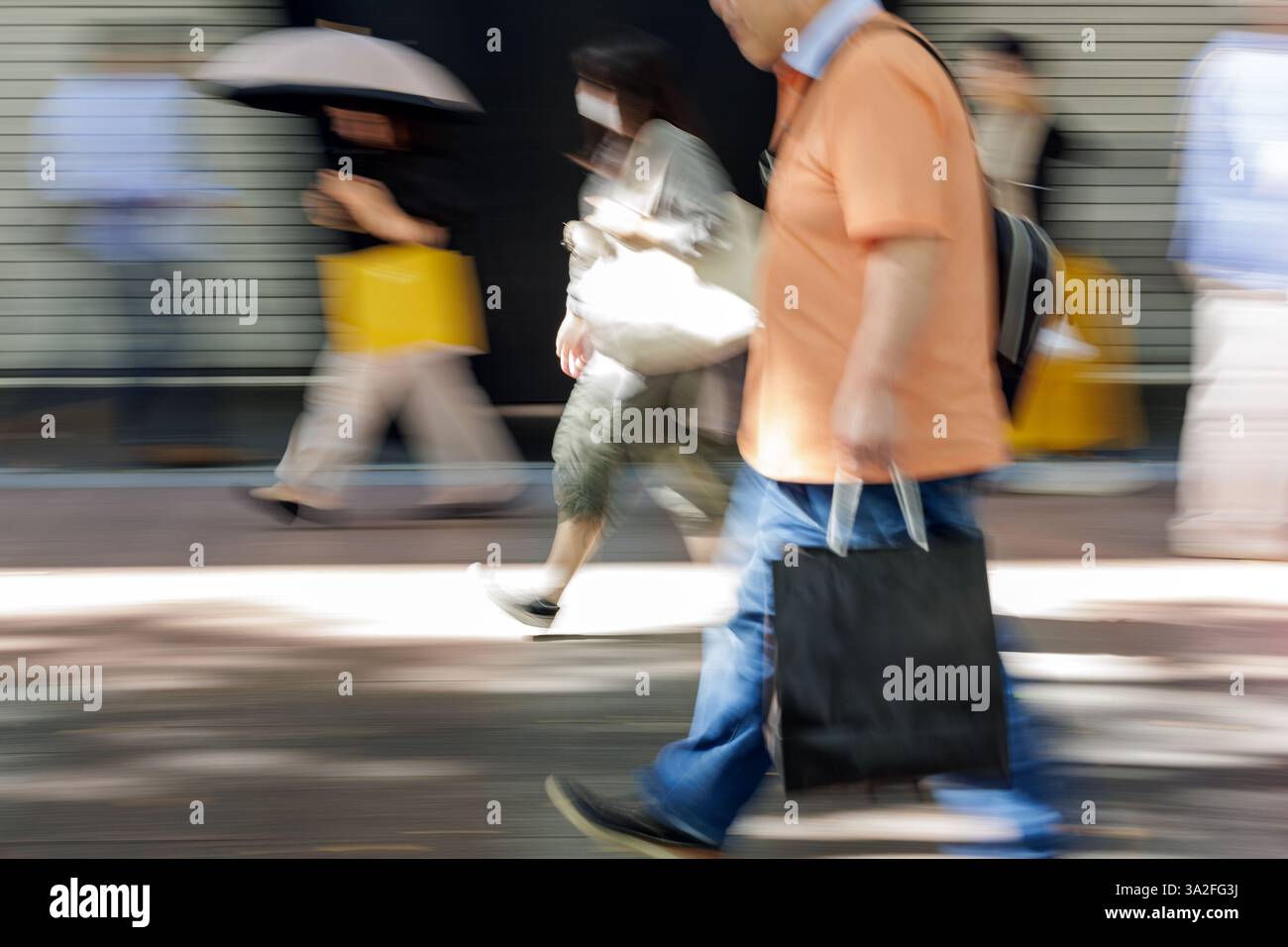 Street scene captures people walking briskly along city street. Various ...
