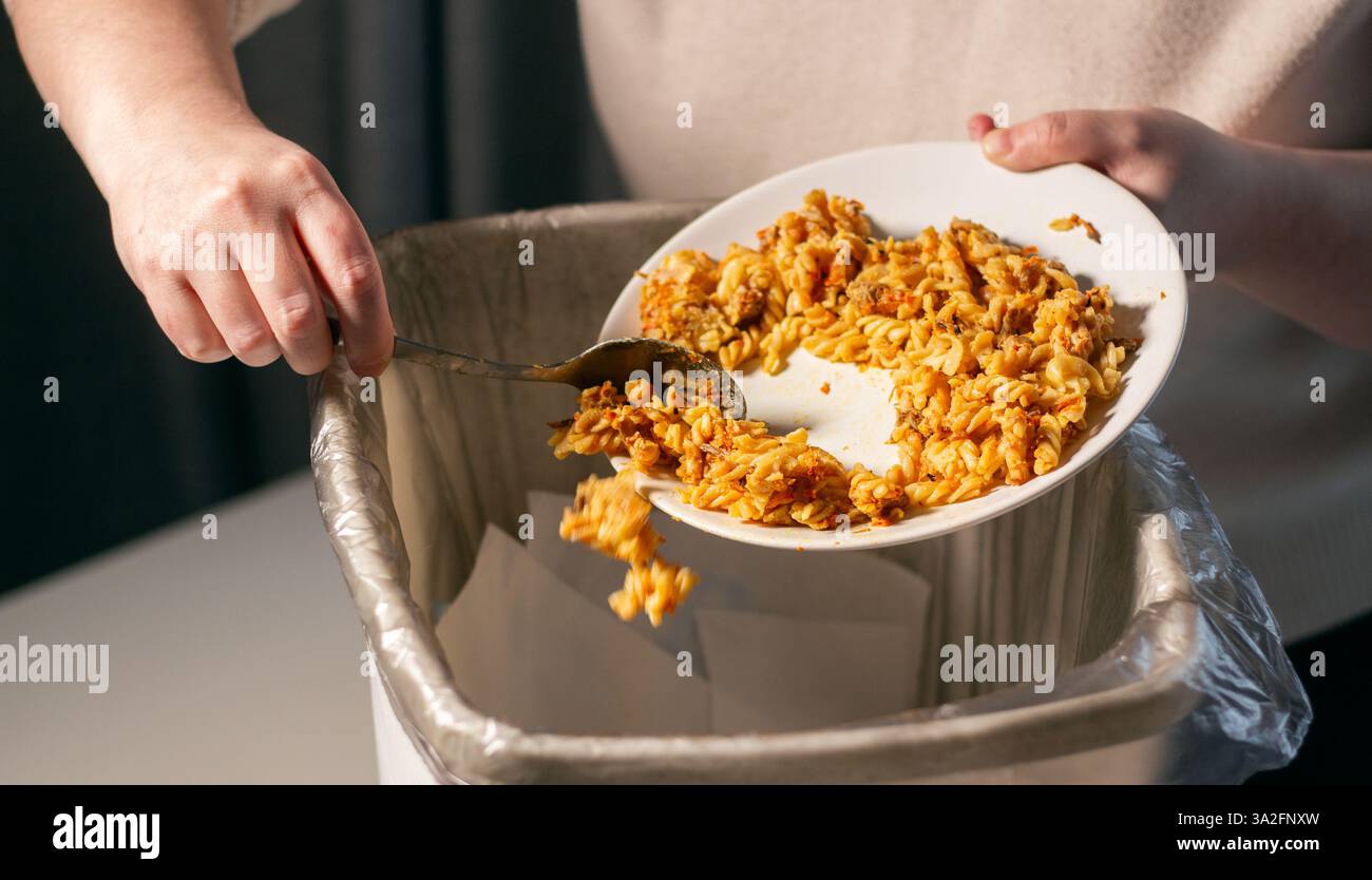 Woman throwing away food leftovers into garbage bin trash. Scraping ...