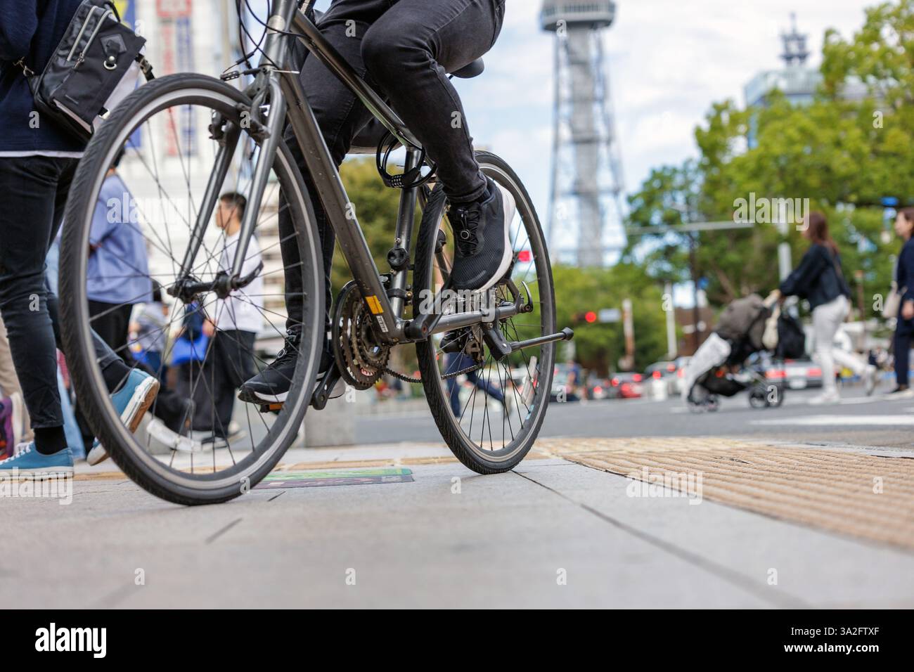 Bicyclist crossing onto sidewalk with Japanese yellow braille Tenji ...
