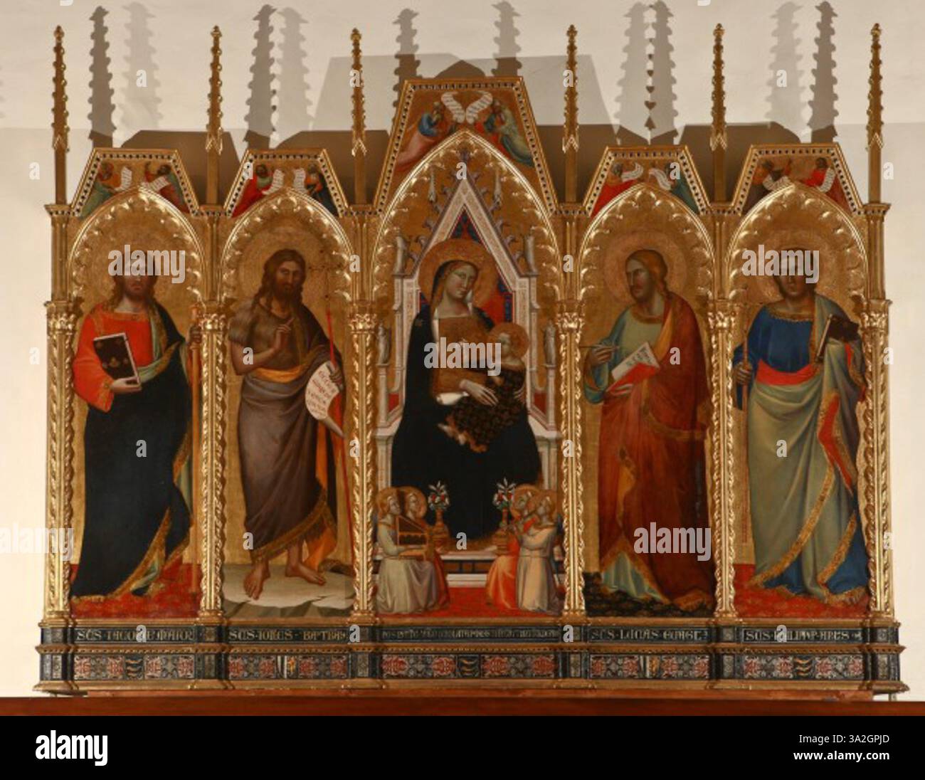 This painting by Taddeo Gaddi shows the Madonna and Child enthroned with several saints. The ...