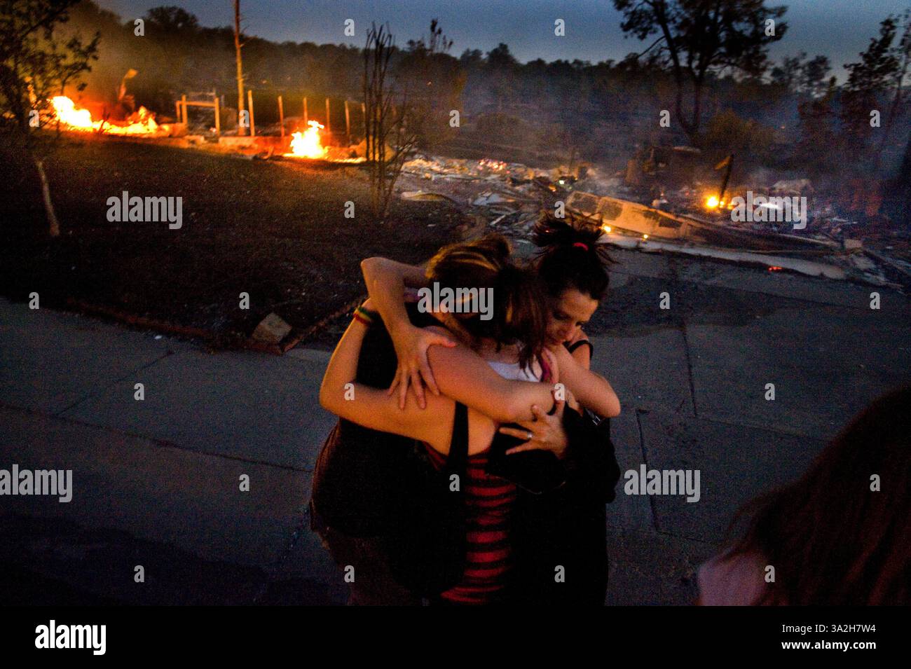 Marla Gordon holds her daughters as they looked at their burned down ...