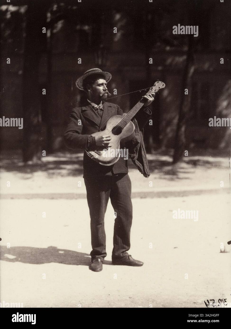 A 1899-1900 photograph by Eugène Atget of a street guitar player ...
