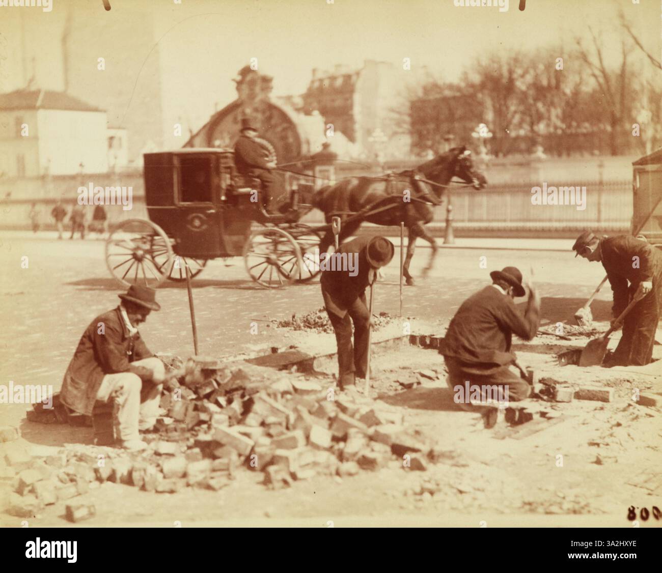 This untitled photograph captures street workers (paveurs) laying ...