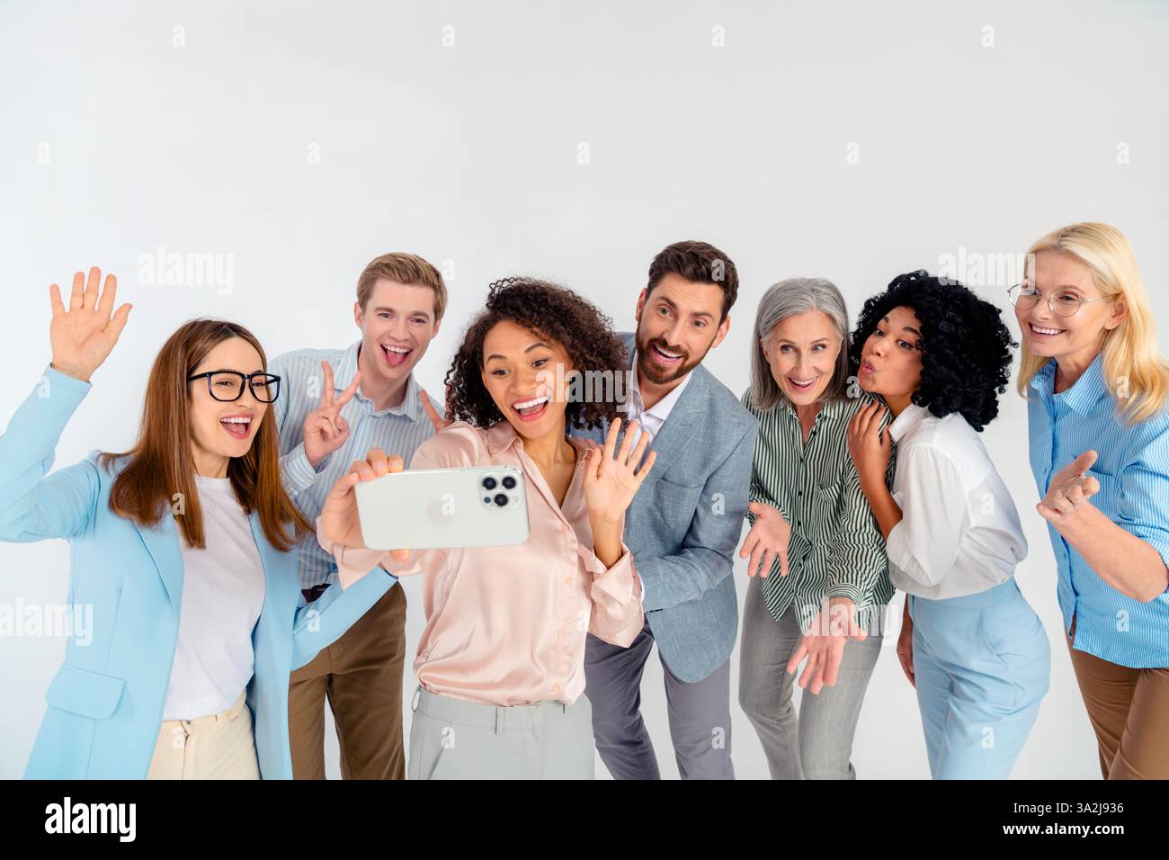 Diverse professional team taking a cheerful group selfie in a formal ...