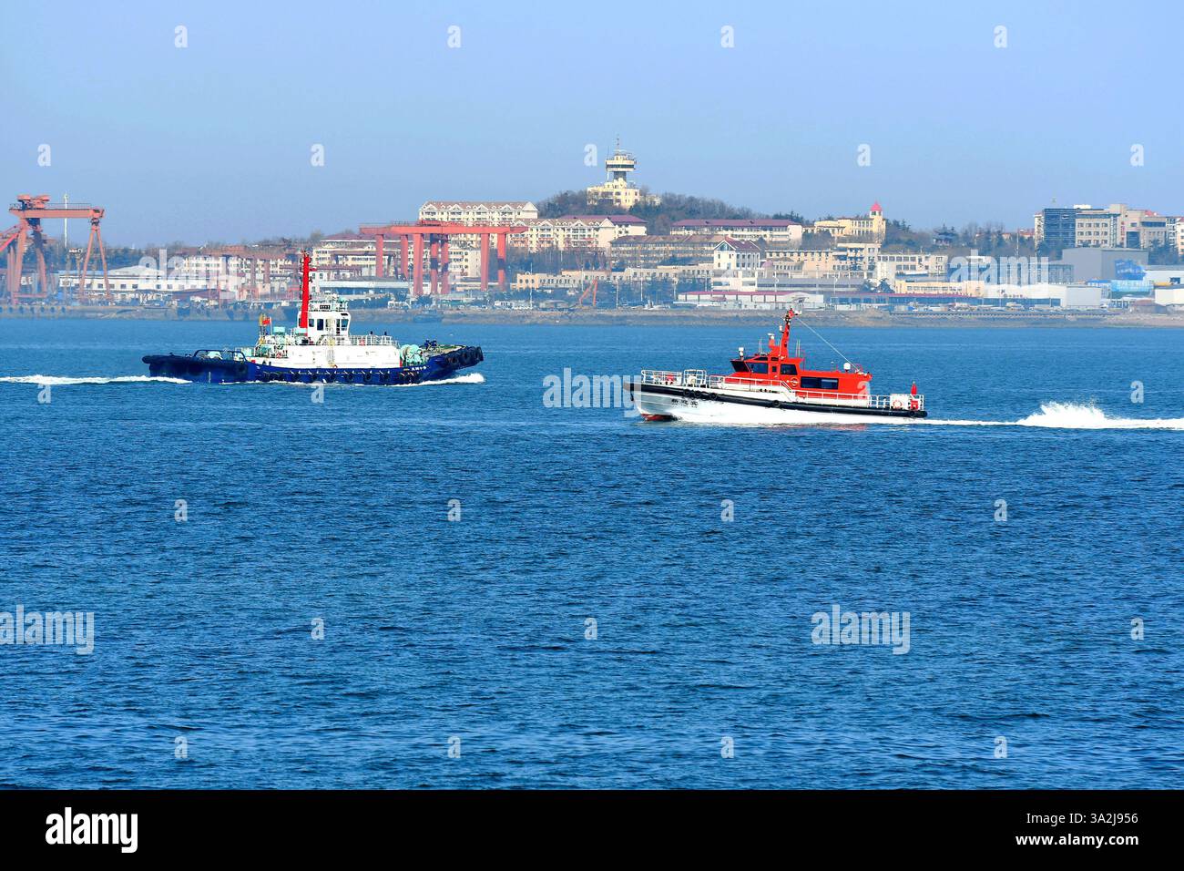 Auxiliary vessels sail in the channel at Qingdao Port, a port in ...