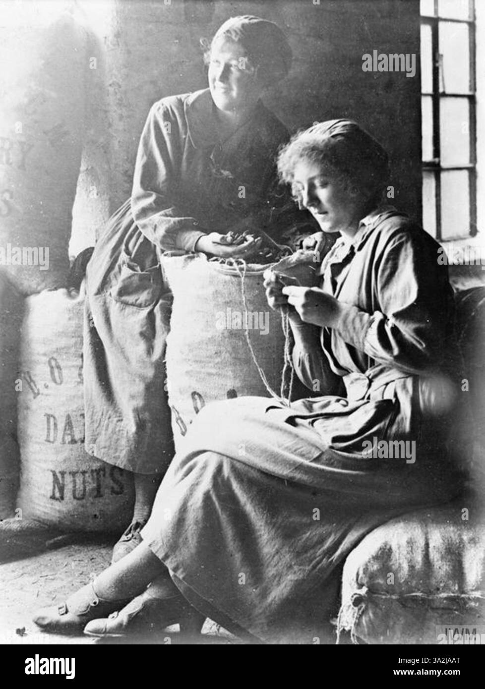 The Employment of Women in Britain, 1914-1918 Two female oil workers sew up bags for compound ...