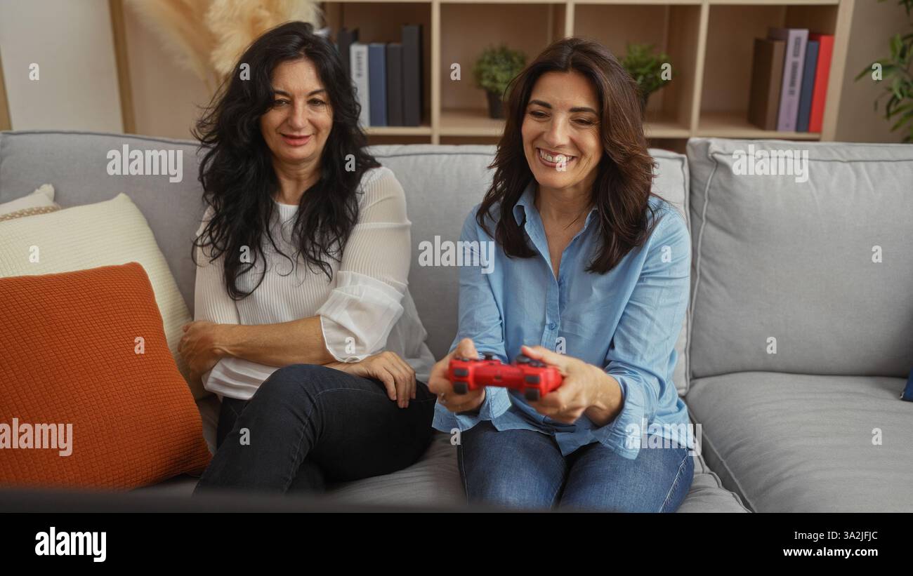 Two middle-aged women sitting together on a comfortable sofa in a cozy ...