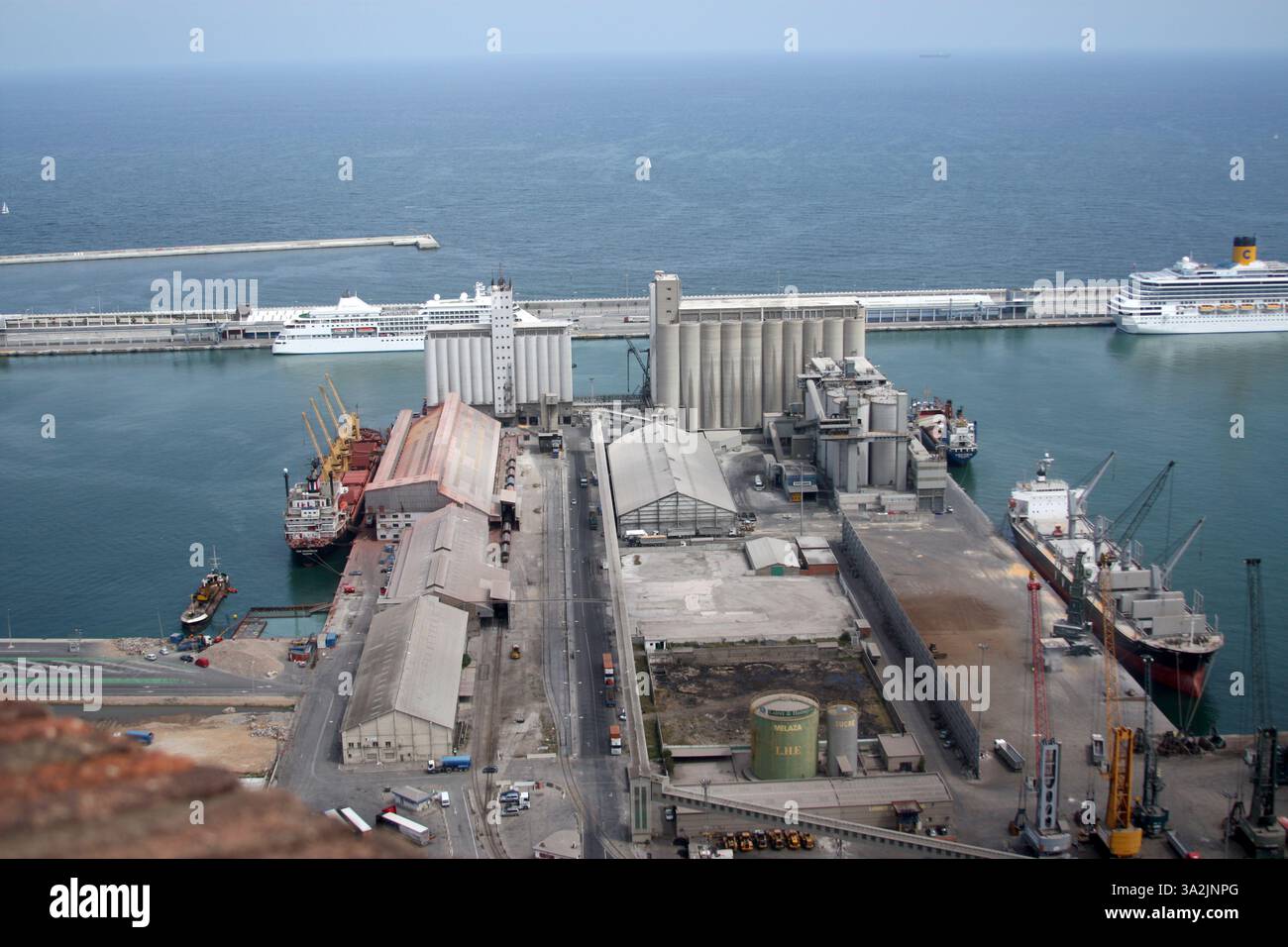 Active port with cargo ships, silos, and a cruise ship. Aerial view ...