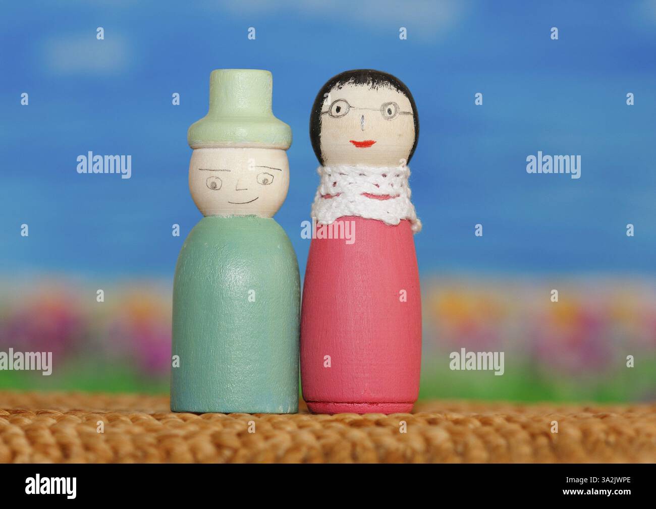Two funny painted wooden cones man and woman in front of a colourful ...