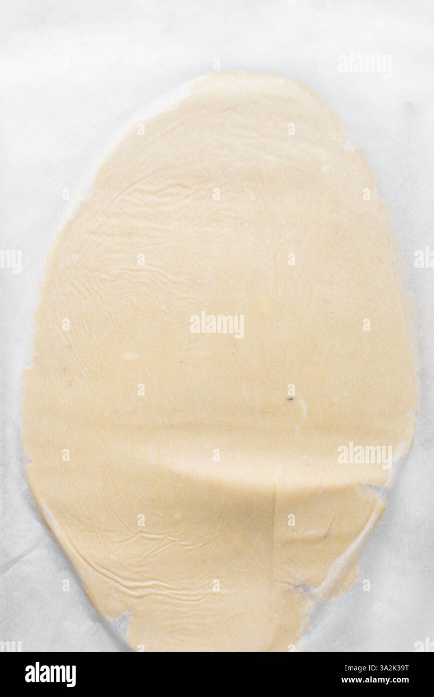 Top view of sugar cookie dough rolled between parchment paper, process ...