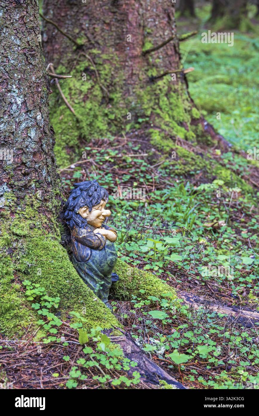 Troll is a being in Nordic folklore leaning against a tree root in the ...