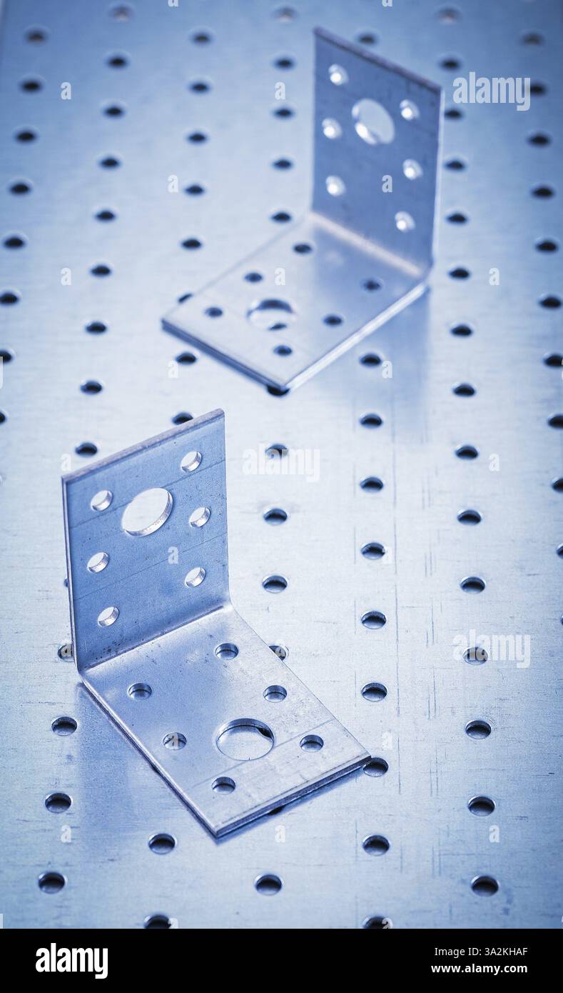 Stainless perforated angle fasteners on metallic background ...