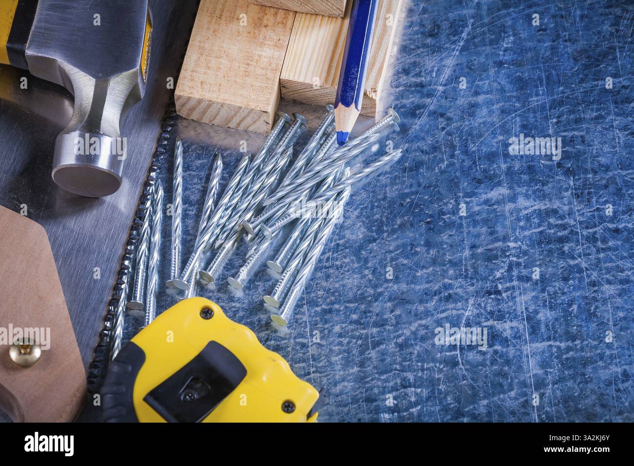 Steel nails hammer wooden bricks hacksaw pencil and tape-line on ...