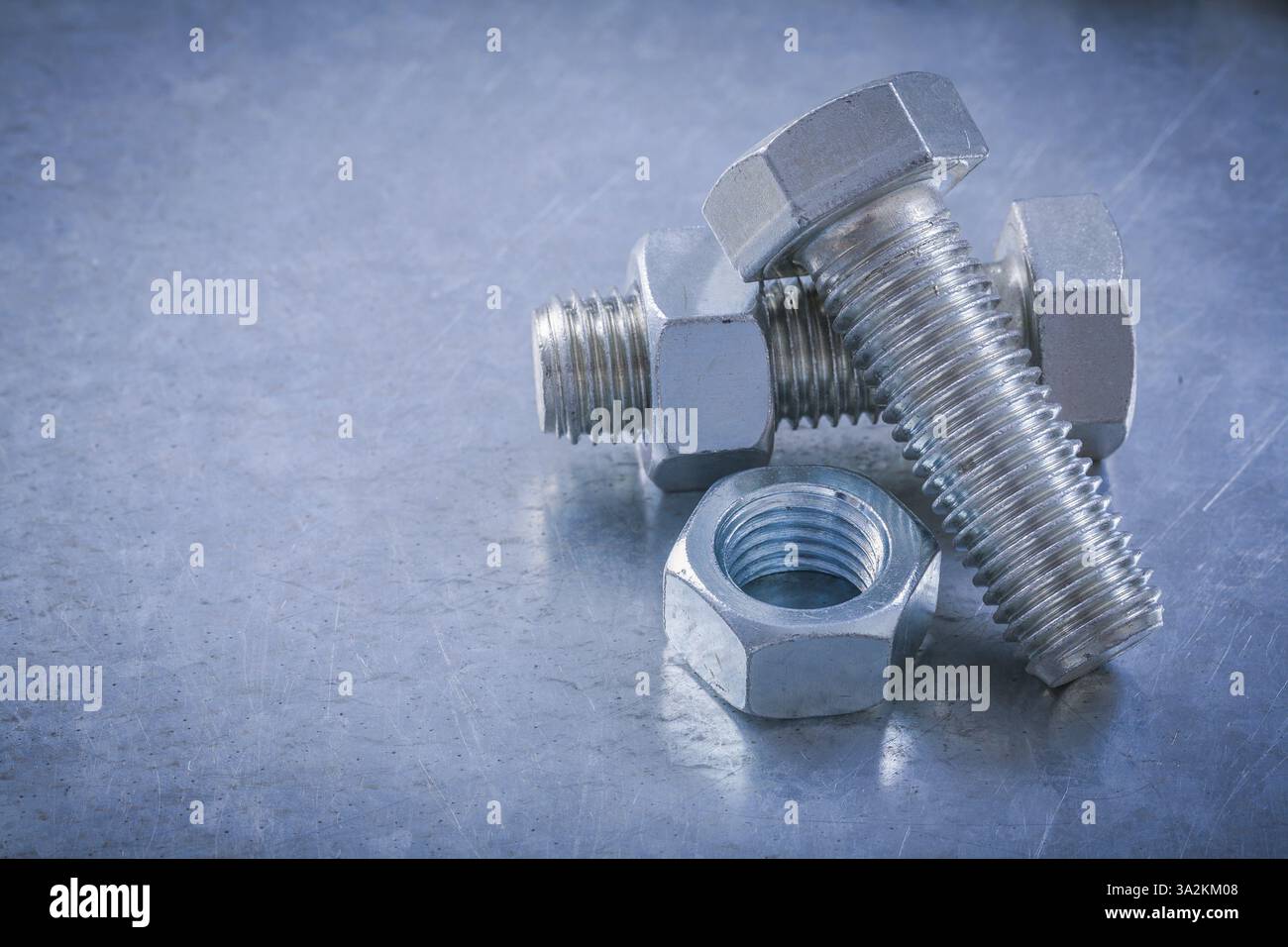 Stainless threaded bolts screw-nuts on scratched metallic background ...