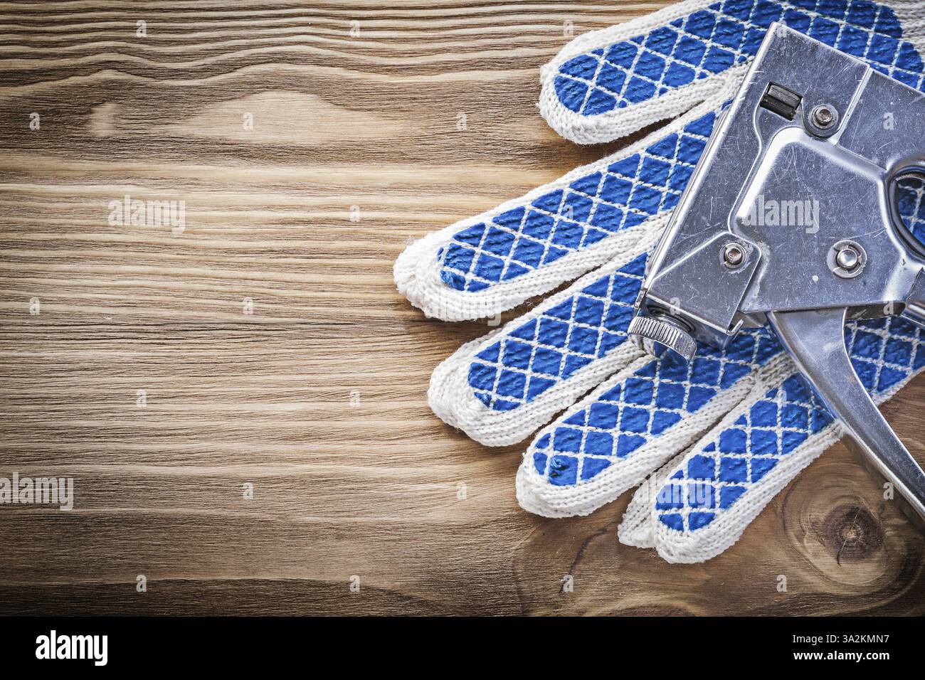 Set of stapler gun safety gloves on wooden board Stock Photo - Alamy