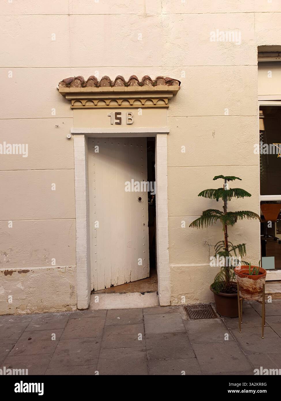 Building facade with a weathered white door and "15 B" inscription ...