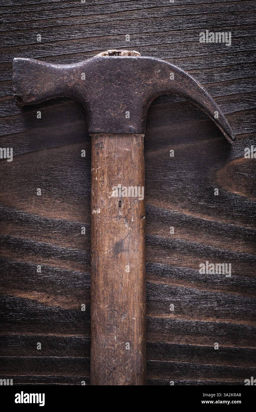 Rusty obsolete claw hammer on vintage dark wooden board construction ...