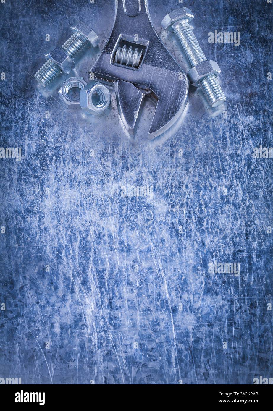 Steel adjustable spanner screw-nuts and threaded bolts on scratched ...