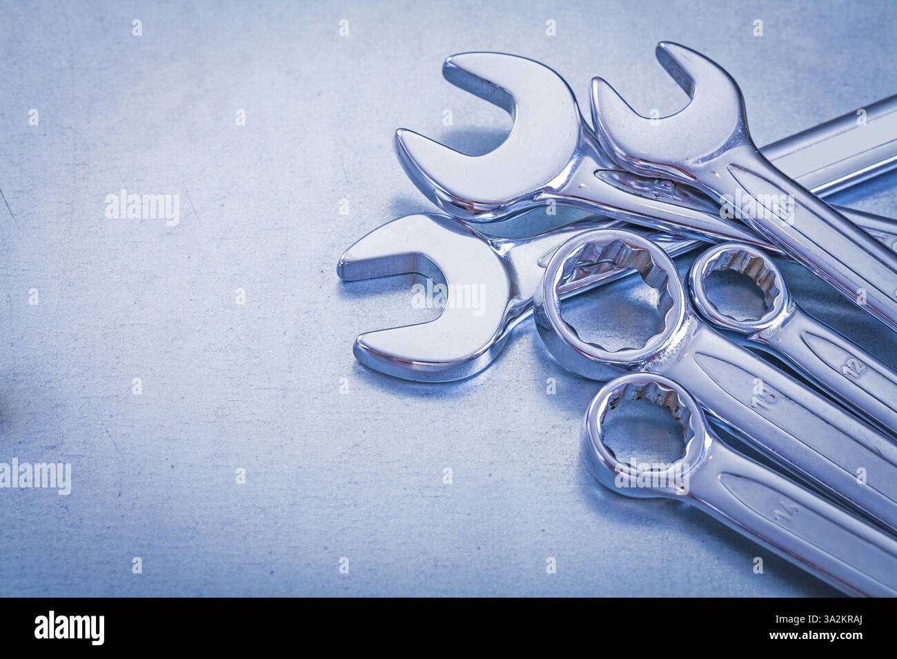 Steel open-end wrenches and flat spanners on metallic background ...