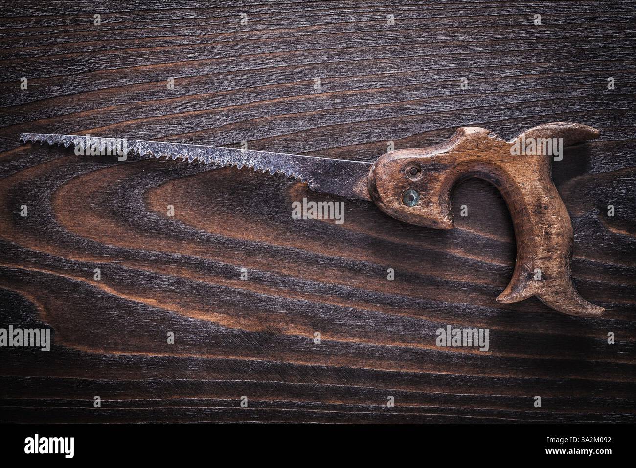 Rusty metal hand saw on vintage dark wooden board top view construction ...