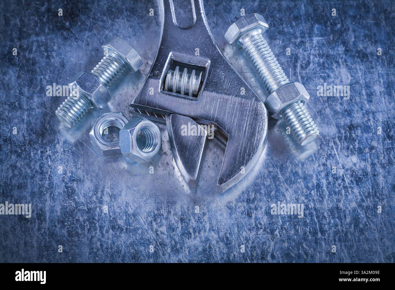 Steel adjustable spanner screw-nuts and threaded bolts on scratched ...