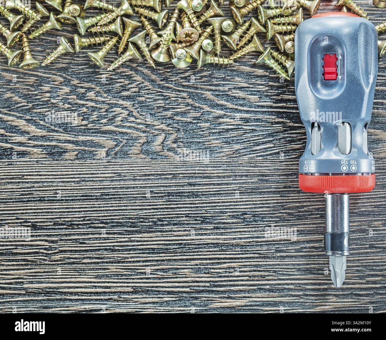 Screwdriver tapping screws on wood board top view Stock Photo - Alamy