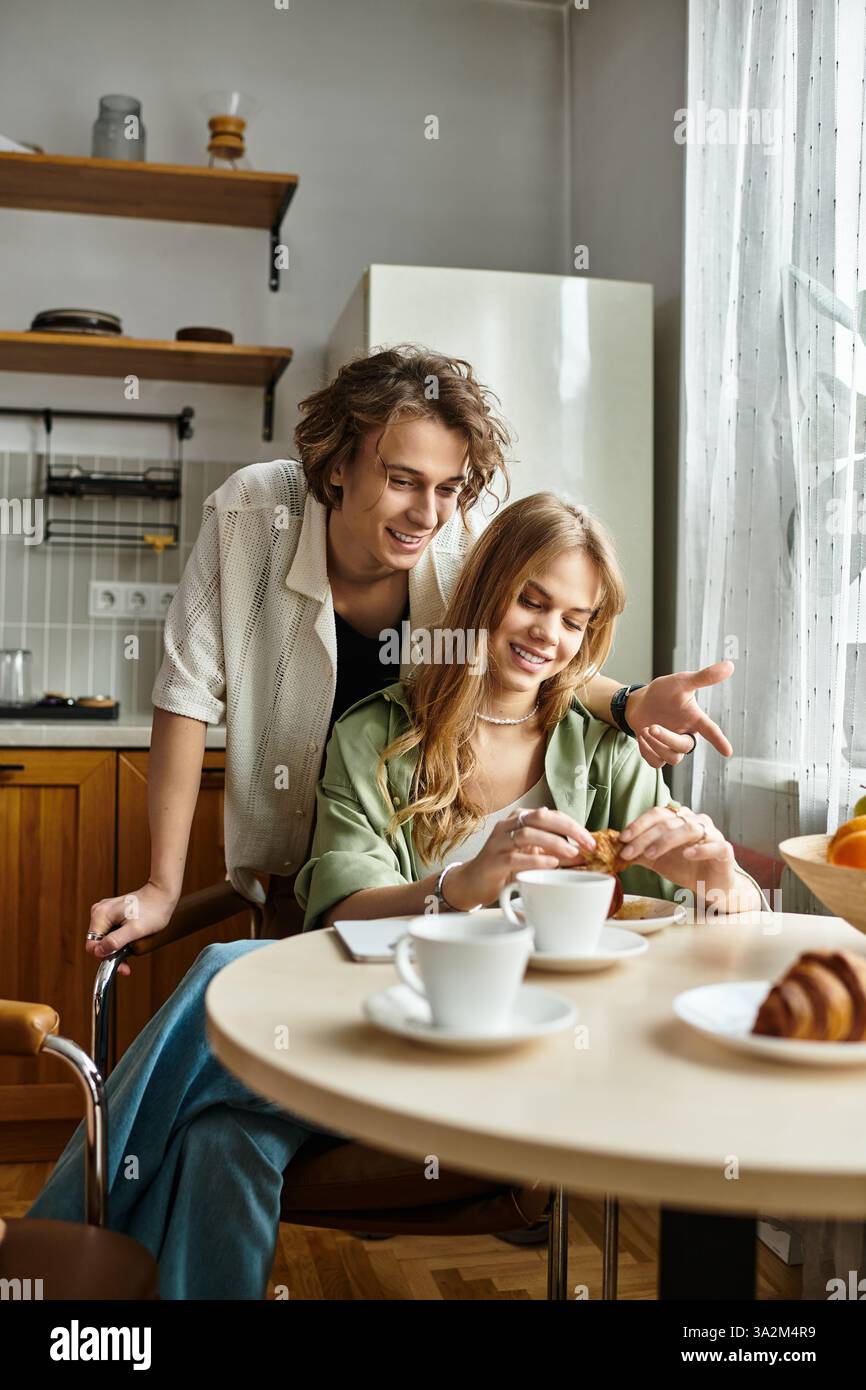 A loving couple enjoys breakfast together, sharing smiles and pastries ...