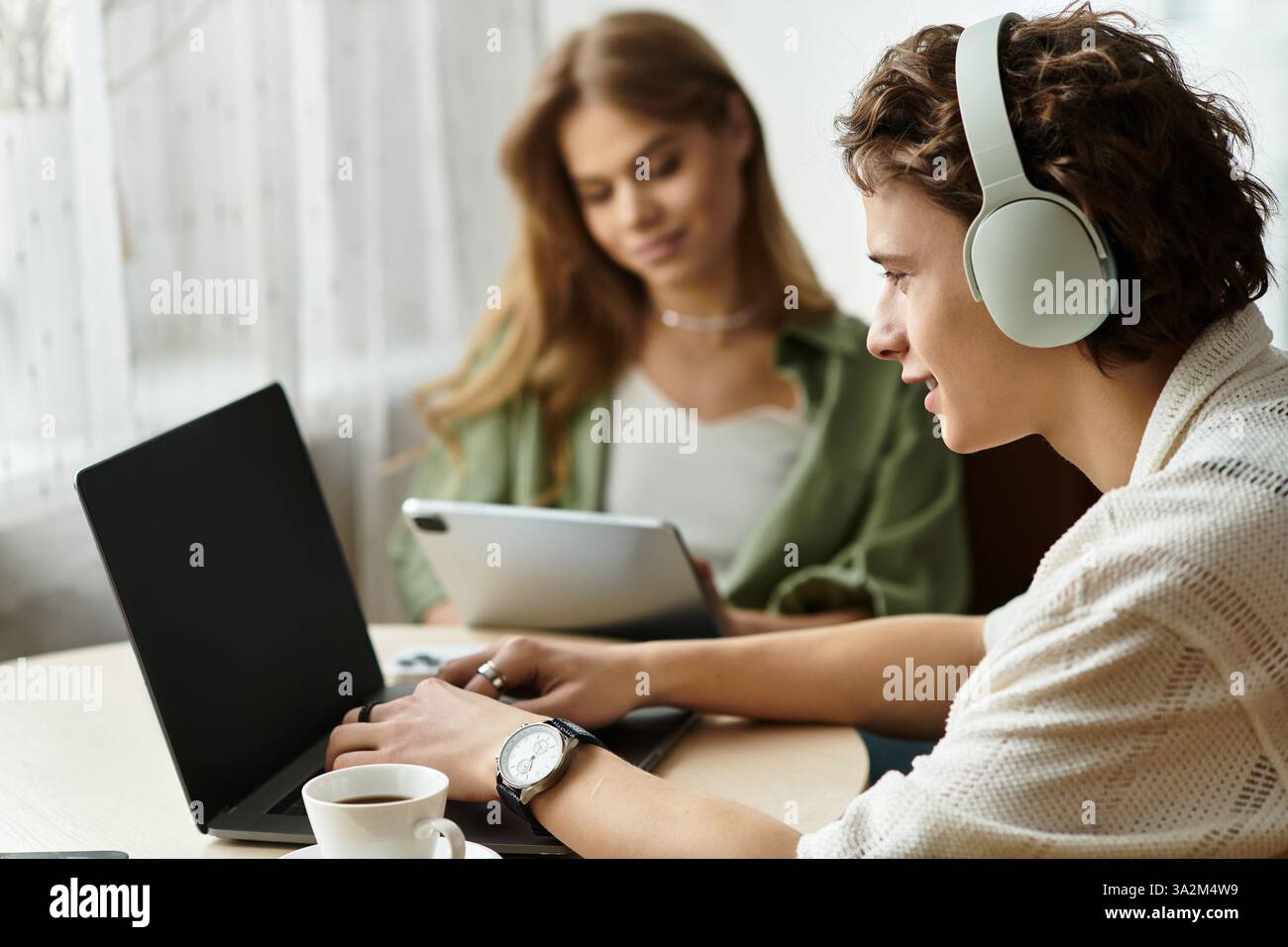 Young couple sits together in a comfortable setting, sharing moments ...