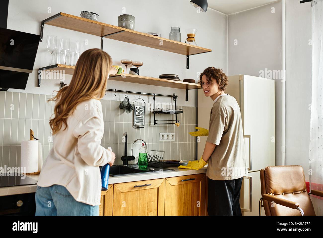 Loving couple enjoys quality time while washing dishes in their warm ...