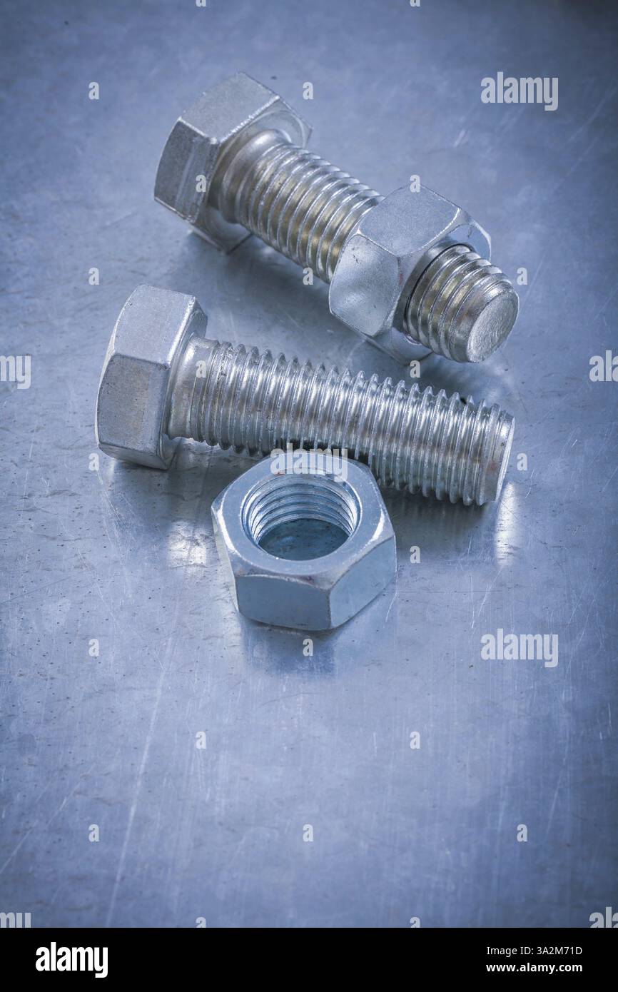 Stainless threaded bolts screw-nuts on metallic background maintenance ...