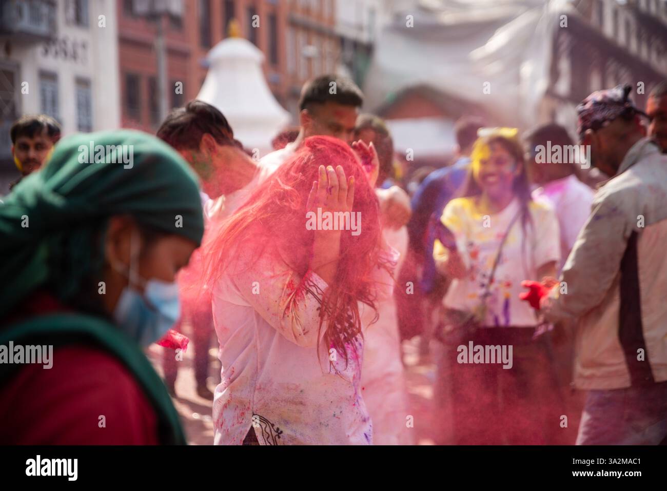 People apply vermilion color powders to each other during the festival ...