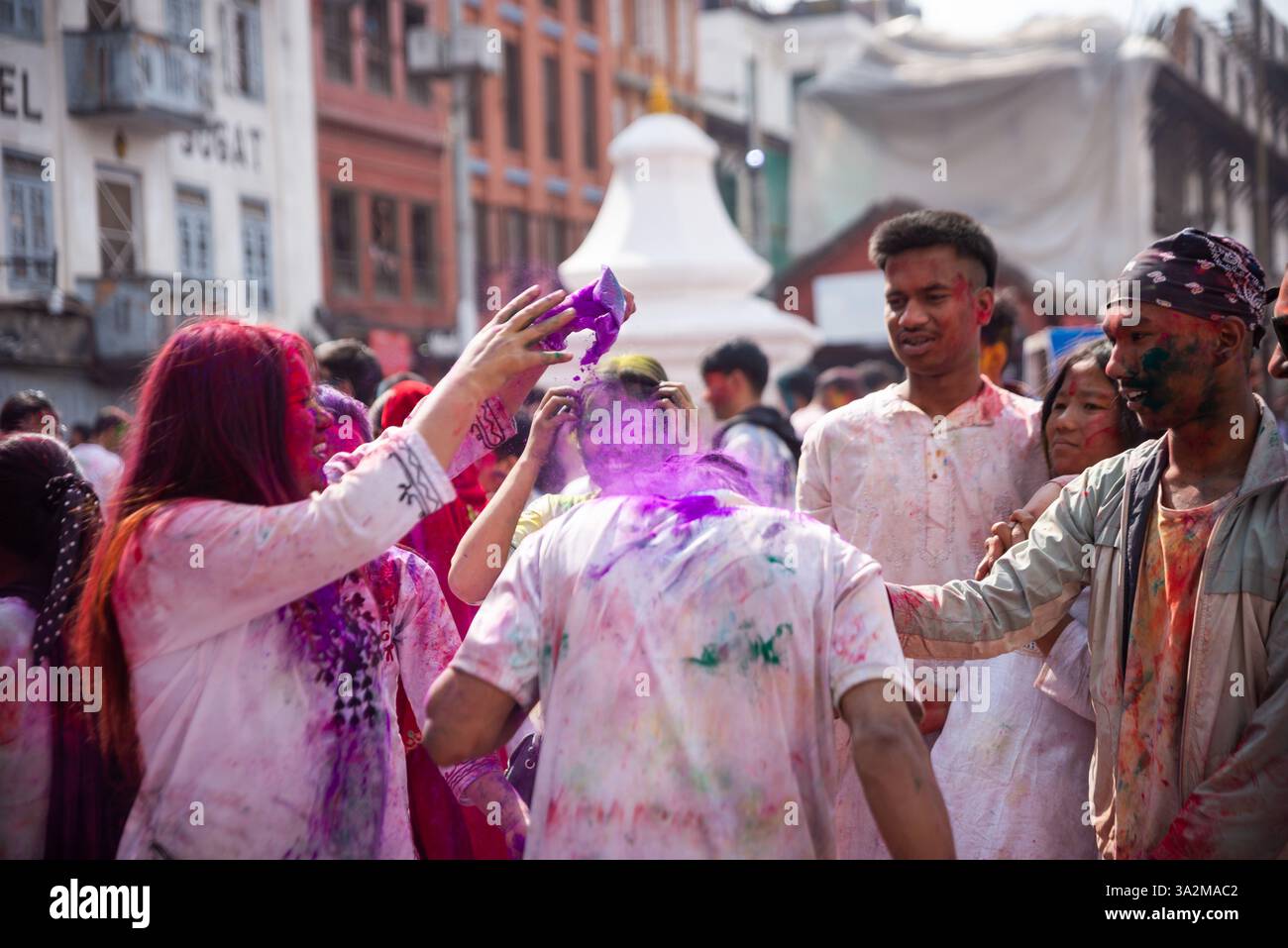 People apply vermilion color powders to each other during the festival ...