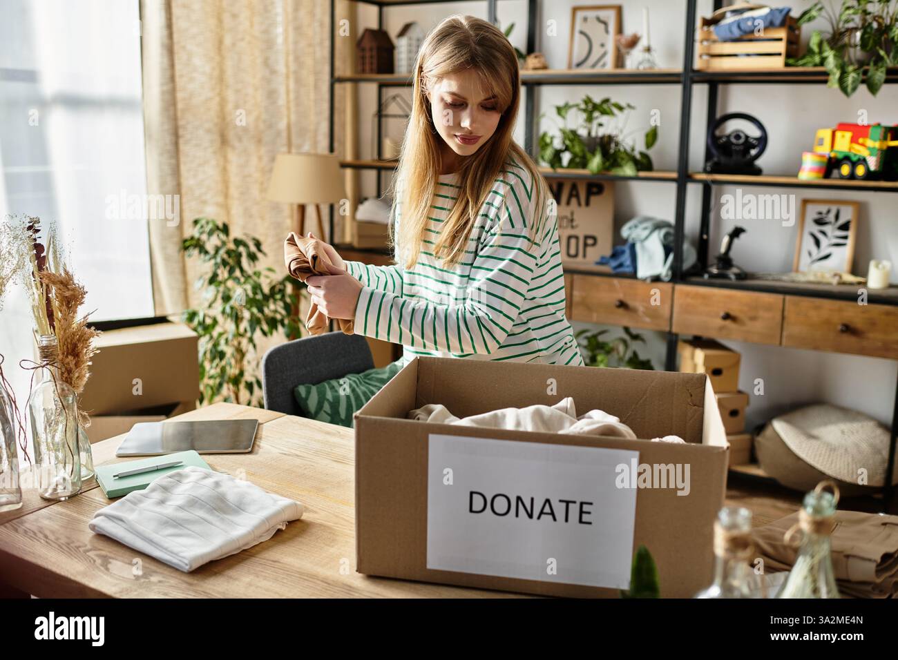 Young woman organizes her wardrobe, preparing items for donation with a ...