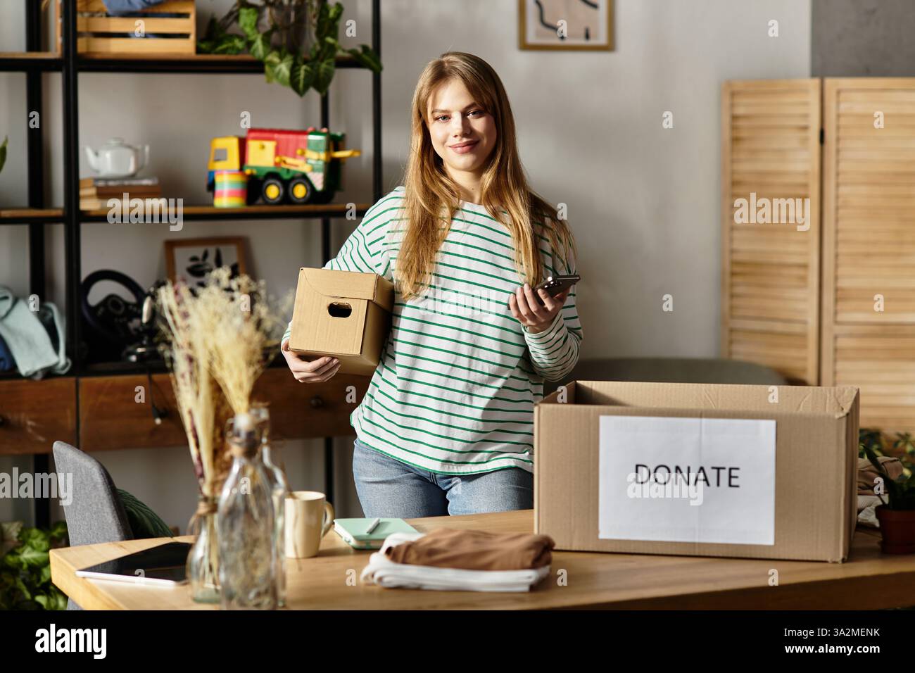 A young woman organizes her clothes and prepares to donate them, promoting sustainability Stock ...