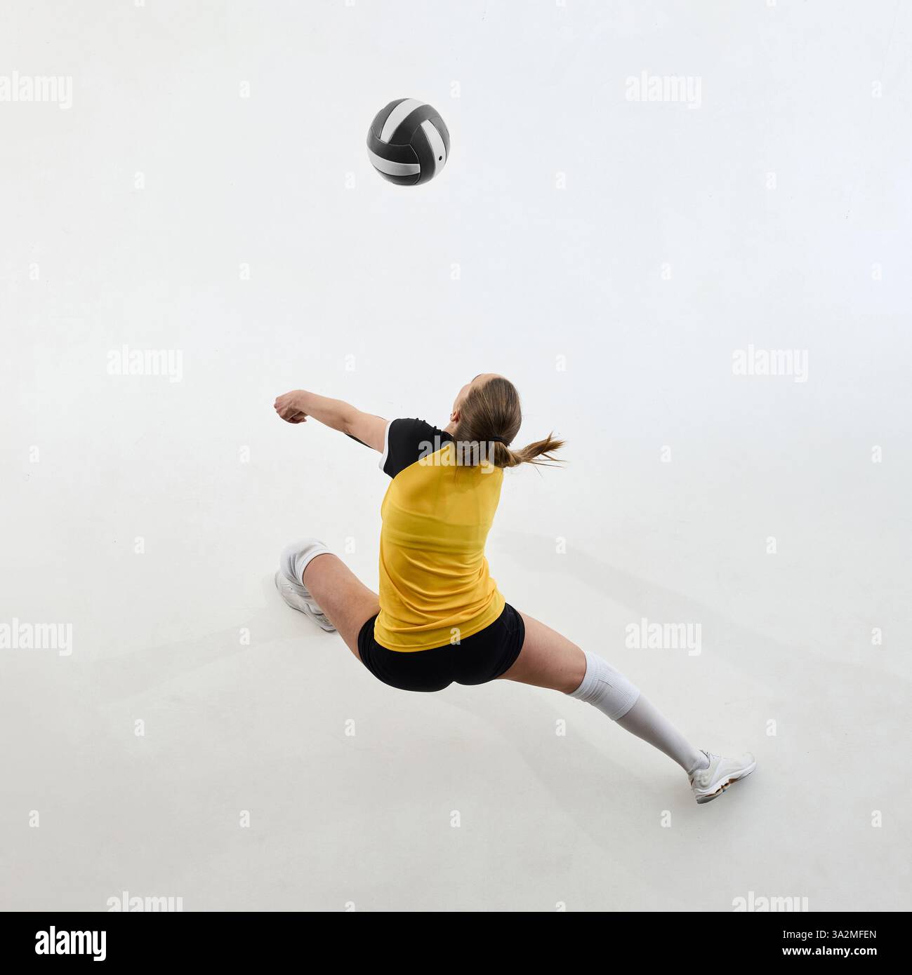 Back view image of young e woman, volleyball player in uniform hitting ...