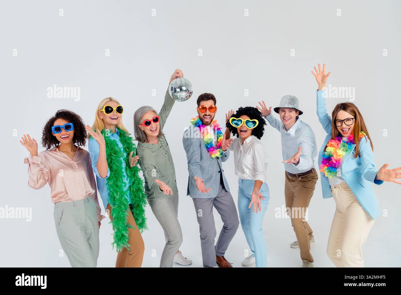 Group of smiling diverse colleagues having fun in colorful party ...