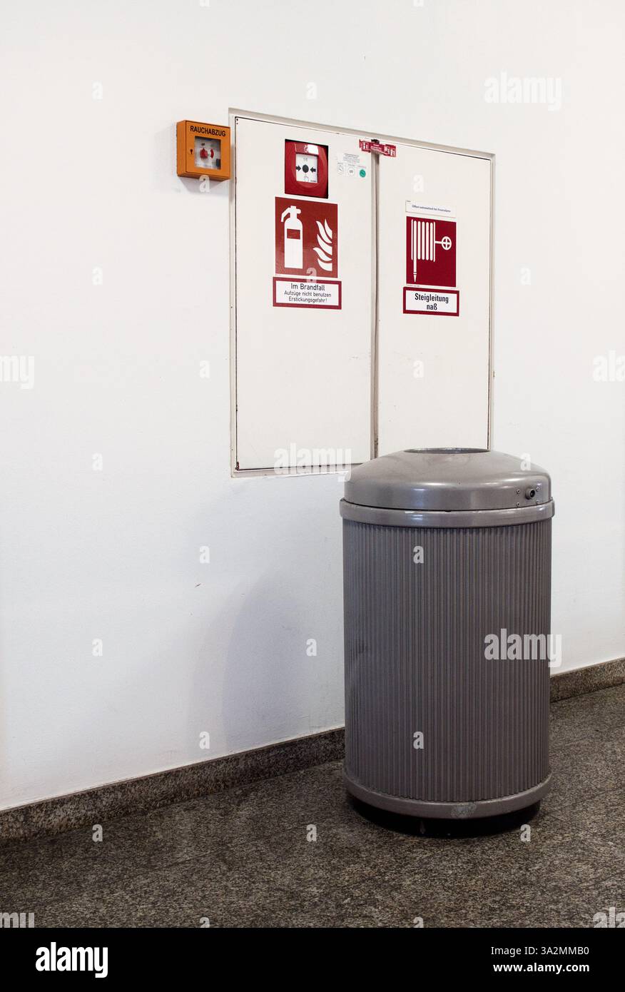 An indoor cabinet containing a fire extinguisher and a fire hose that ...