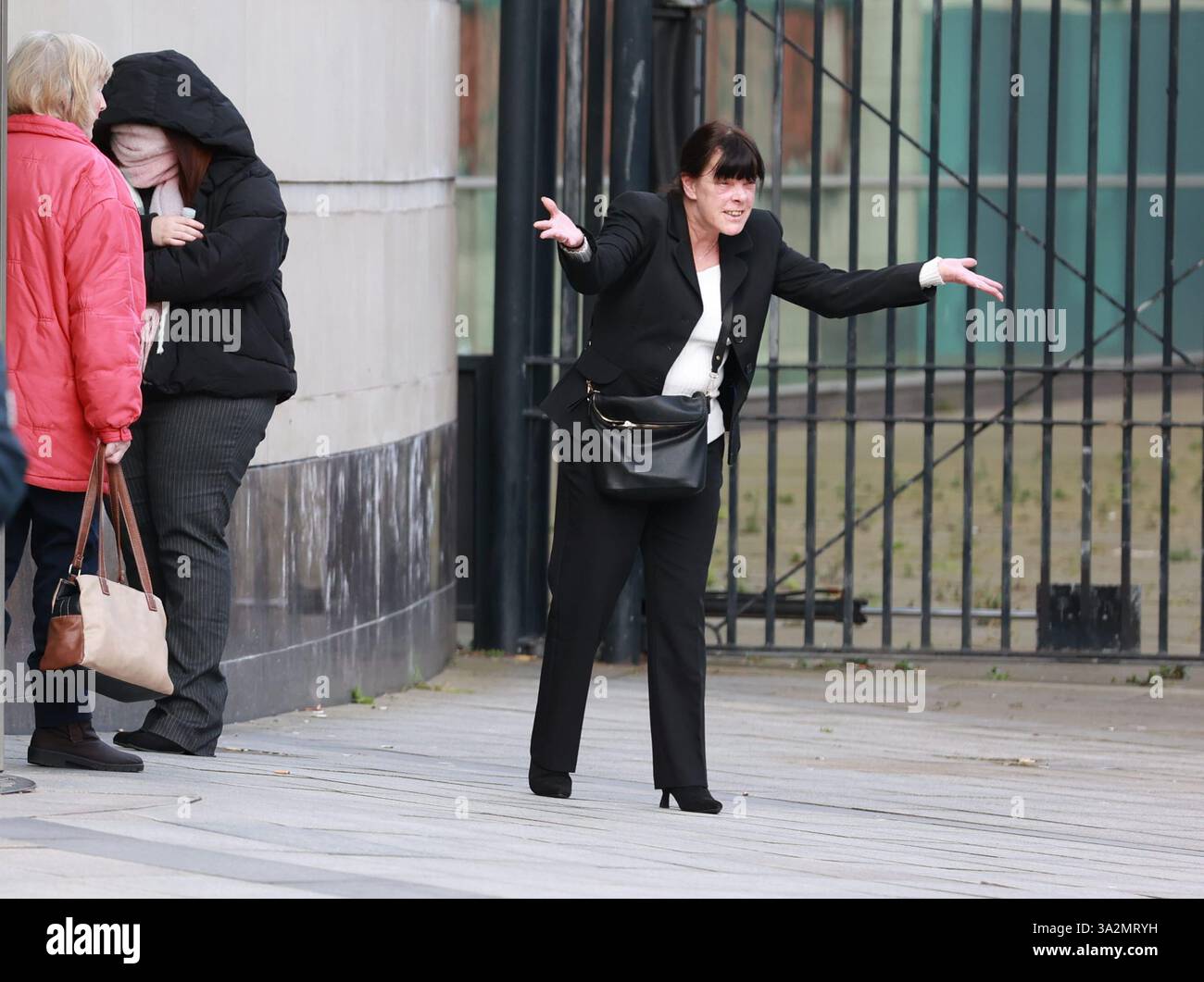 A woman remonstrates with the waiting media as the mother of Lewis ...