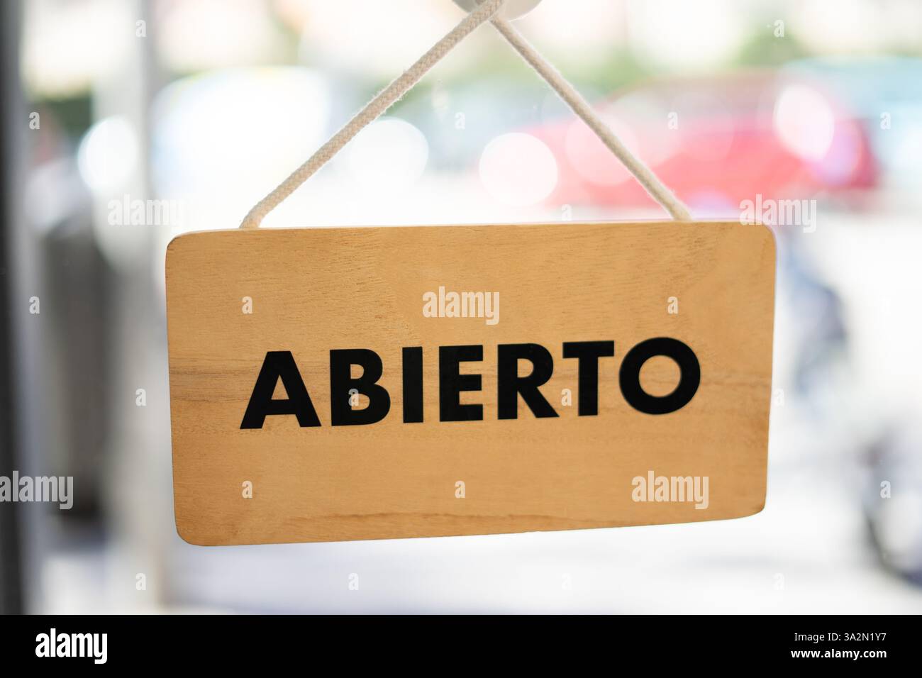 Wooden sign saying abierto (open in spanish) hanging on a glass door ...