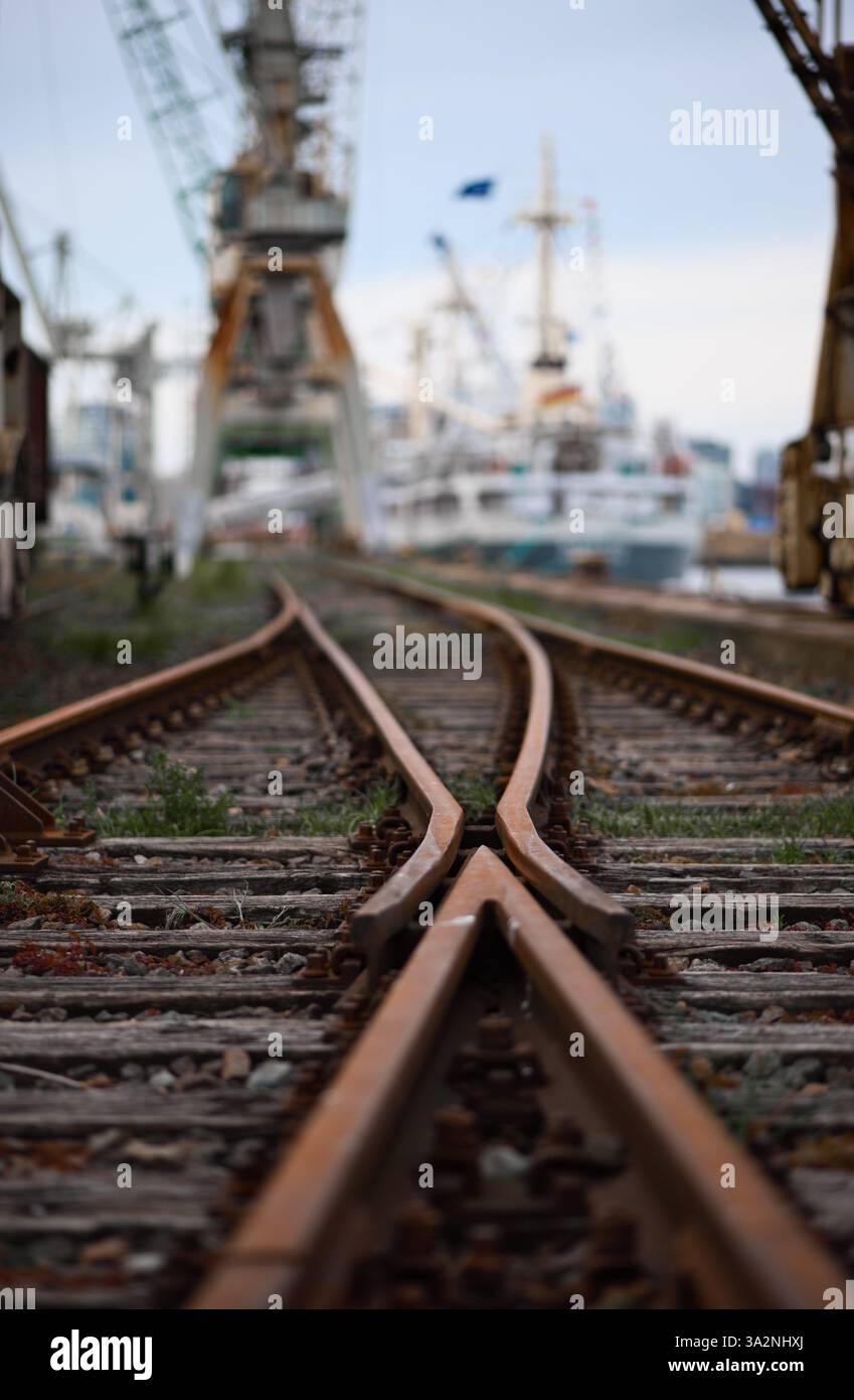 Rusty old train tracks crossing in the Museum Harbor of Hamburg, reflecting the historic ...