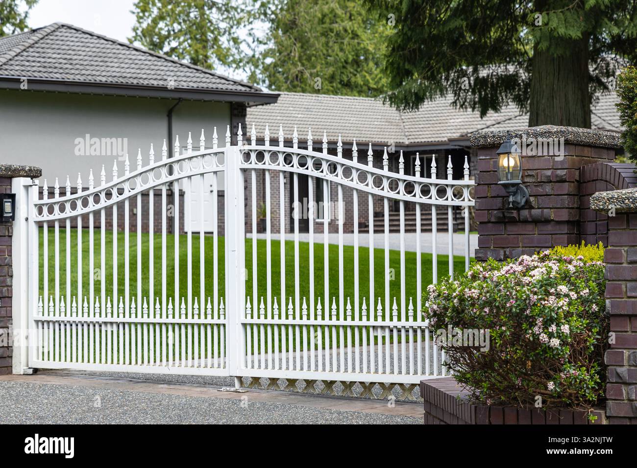 Double wrought-iron gate. Wrought iron gate and stone pillar. White ...