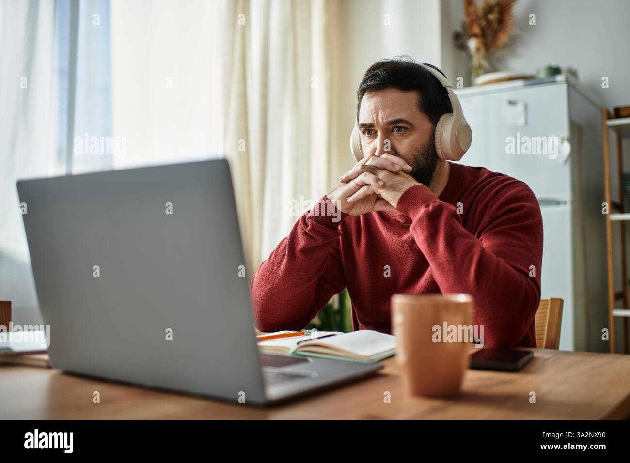 A distinguished elderly man in casual attire ponders intently while ...