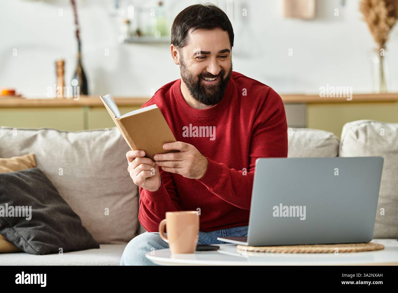 An elderly handsome man smiles as he reads a book, seated comfortably ...